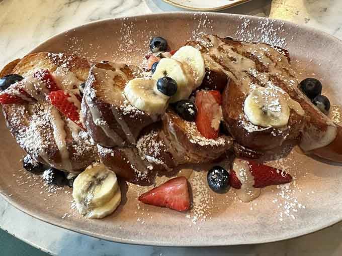 French toast layered with Nutella, fresh fruit, and enough powdered sugar to make Mary Poppins sing with delight.