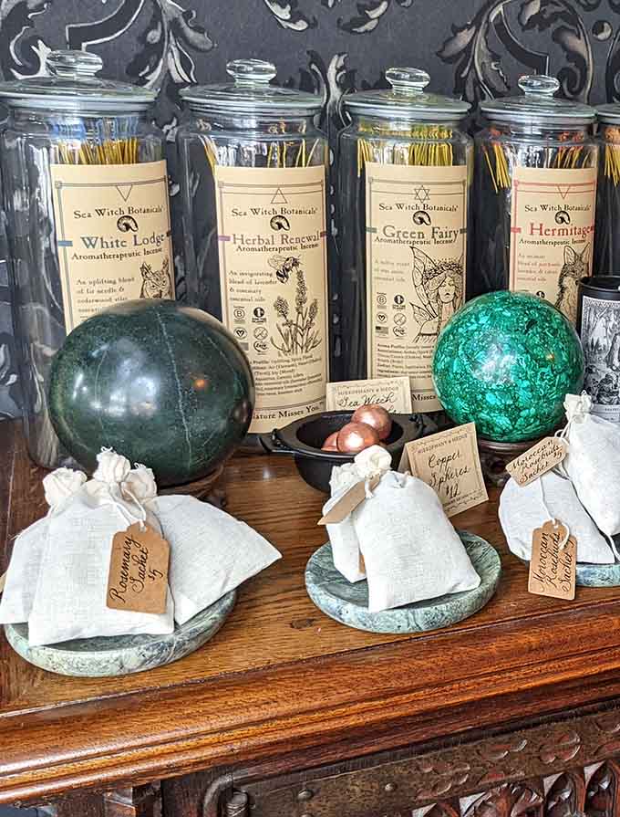 Glass jars of incense beside glowing crystal orbs, creating a display that's equal parts pharmacy and fantasy novel.