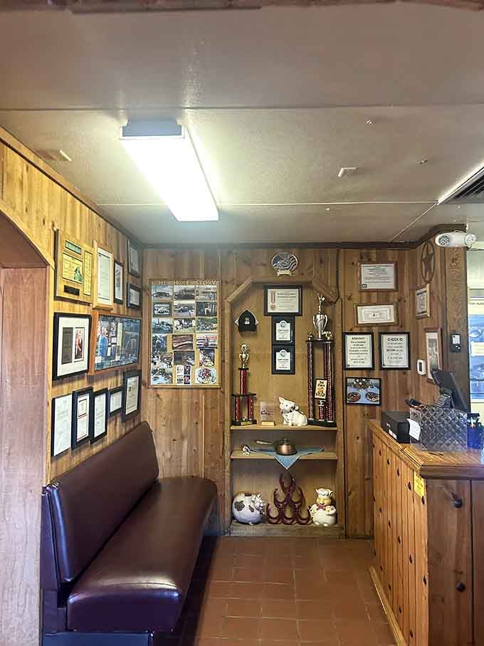 Trophy cases and framed accolades lining the entrance tell the story of barbecue excellence earned over countless smoking hours.