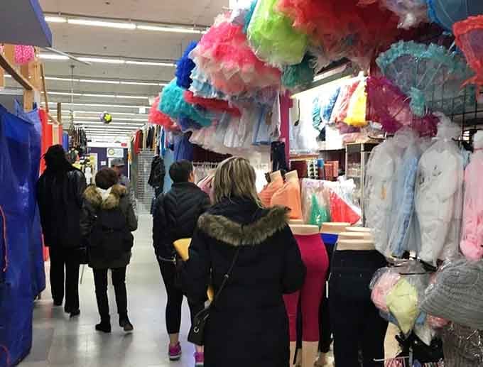Shoppers navigating aisles of colorful party supplies, probably planning celebrations that won't require a second mortgage to fund.