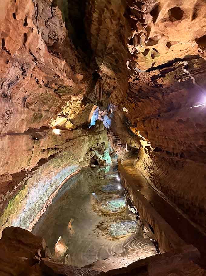 The underground cave system glowing with ethereal light, where ancient rock formations meet modern walkways in perfect harmony.