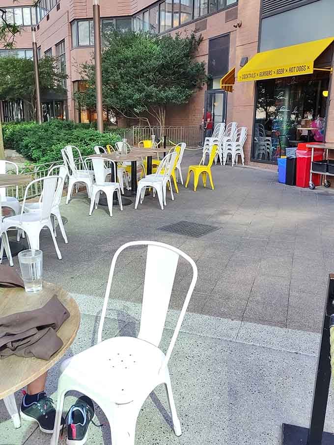 Outdoor seating with cheerful yellow umbrellas and white metal chairs turns sidewalk dining into a proper New York experience year-round.