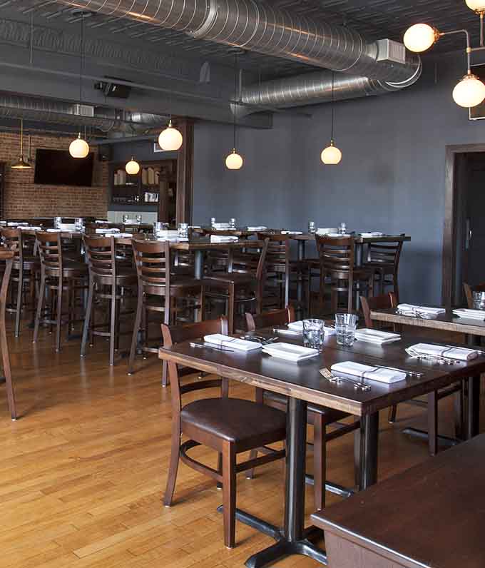 Spacious dining room with tables set and ready, like a stage waiting for the dinner rush performance to begin nightly.