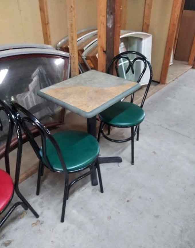 Simple bistro tables and chairs offer practical seating solutions amidst all the glorious chaos surrounding them throughout the space.