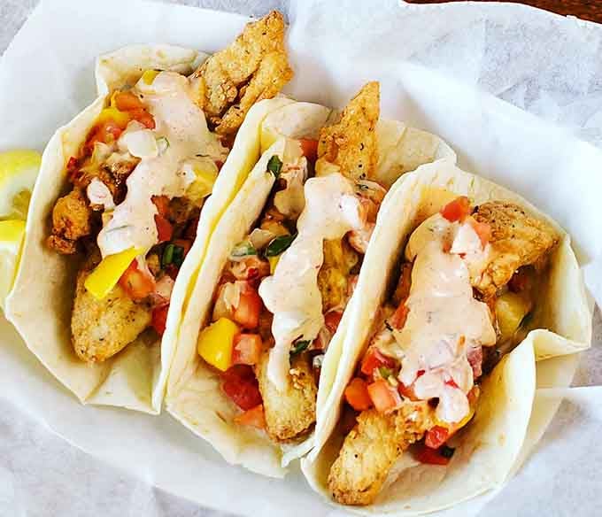 Cod tacos dressed with vibrant toppings and creamy sauce show how versatile great fried fish can truly be.