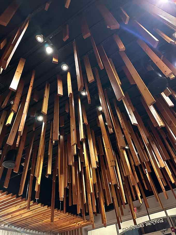 The sculptural ceiling design resembles falling chopsticks frozen in time, pure artistic whimsy overhead.