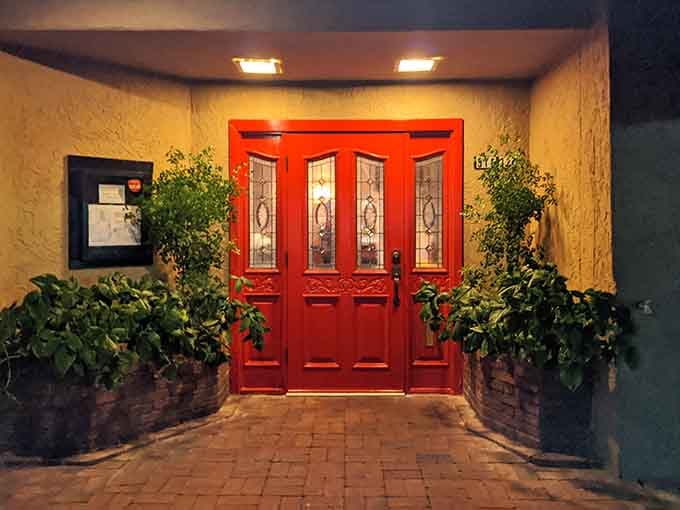 Red doors flanked by greenery, inviting you into what might become your new favorite tradition.