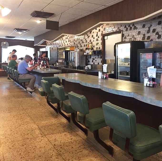 Counter seating with mint green stools offers prime real estate for solo diners and people-watching enthusiasts alike.
