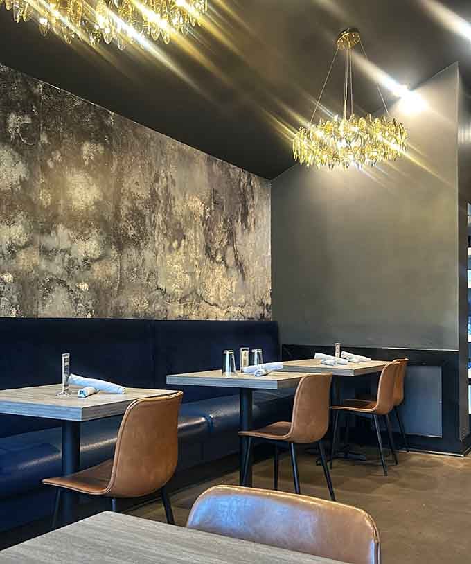 Leather booths and abstract art create an atmosphere where fried chicken feels appropriately celebrated and respected.