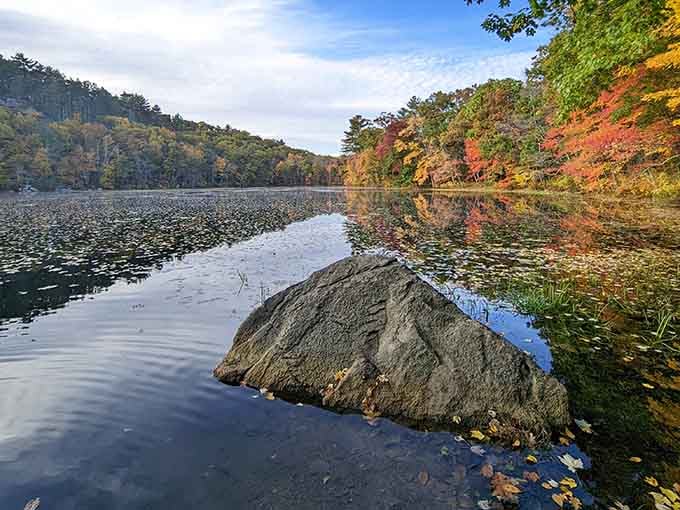 One perfectly placed boulder creating the ideal foreground for fall colors reflected in glassy water beyond.