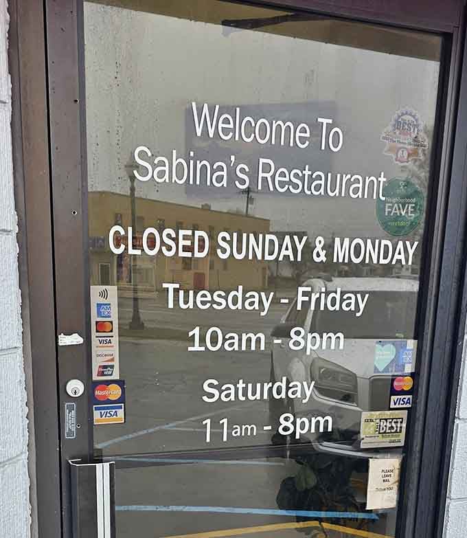 Operating hours posted on the door, closed Sundays and Mondays so the staff can rest up properly.