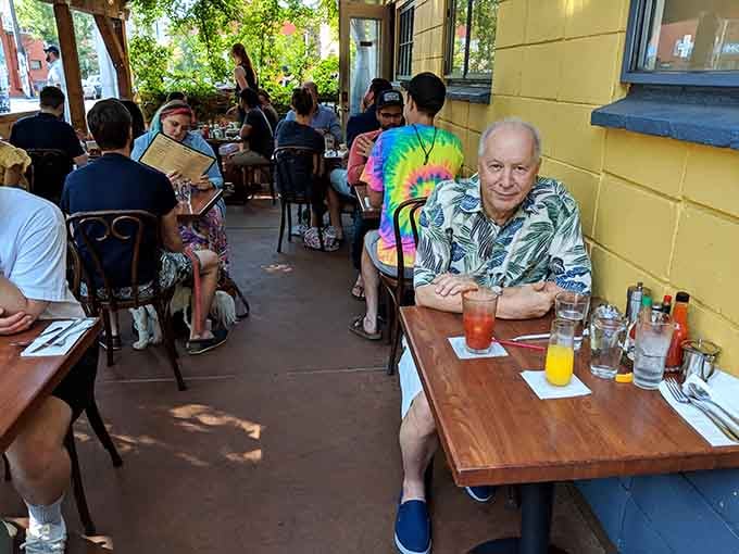 Outdoor seating filled with happy diners soaking up sunshine alongside their chicken and waffles on a perfect day.