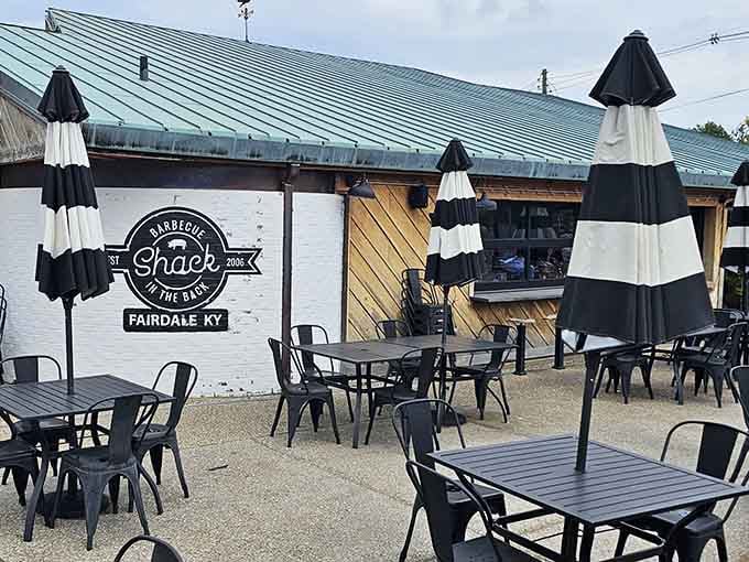 Outdoor seating with striped umbrellas offers the perfect spot for enjoying barbecue under Kentucky skies.