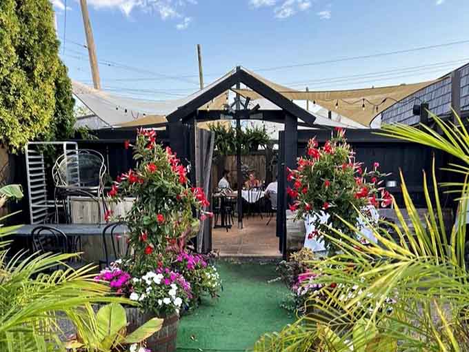 The garden entrance blooms with flowers and promise, inviting you into an outdoor dining experience that feels like a vacation.