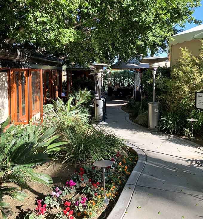 The garden pathway welcomes you with lush landscaping that promises something special awaits inside those doors.