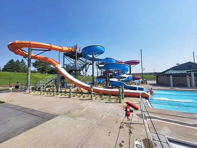 Orange and blue slides stand ready like colorful sentries, guarding the gateway to screams, splashes, and unforgettable summer memories.