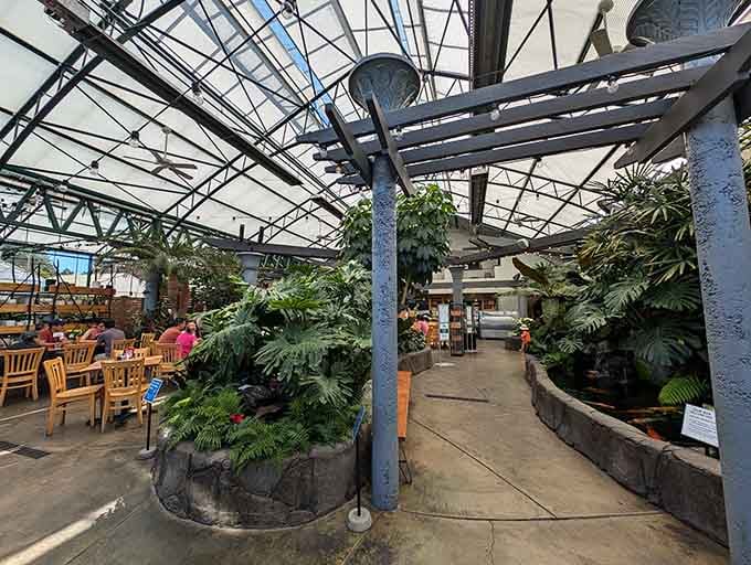 The pathway to paradise winds through plants and past tables, inviting you deeper into this unexpected urban oasis.