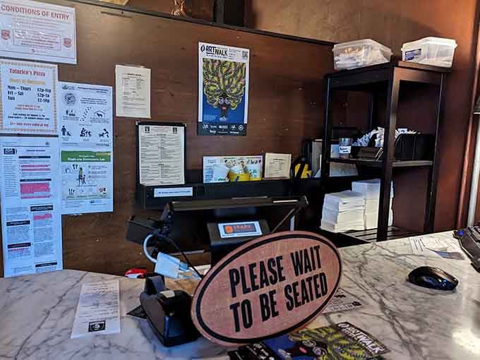 Please wait to be seated, because navigating this pizza palace requires professional guidance and spatial awareness skills.