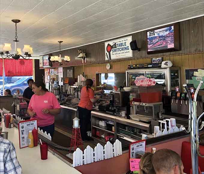 Behind the counter, staff work their magic while model trains circle above, multitasking at its most whimsical and wonderful.
