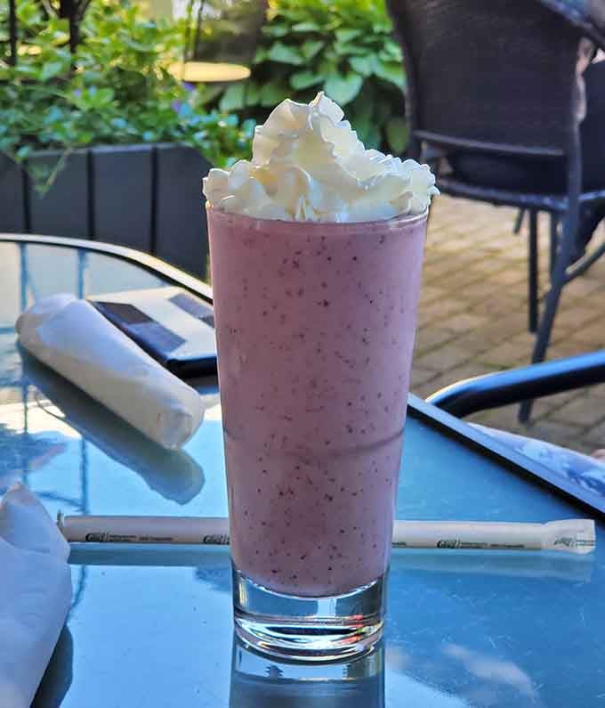 Berry smoothie topped with whipped cream: liquid happiness in a glass, no blender required at home.