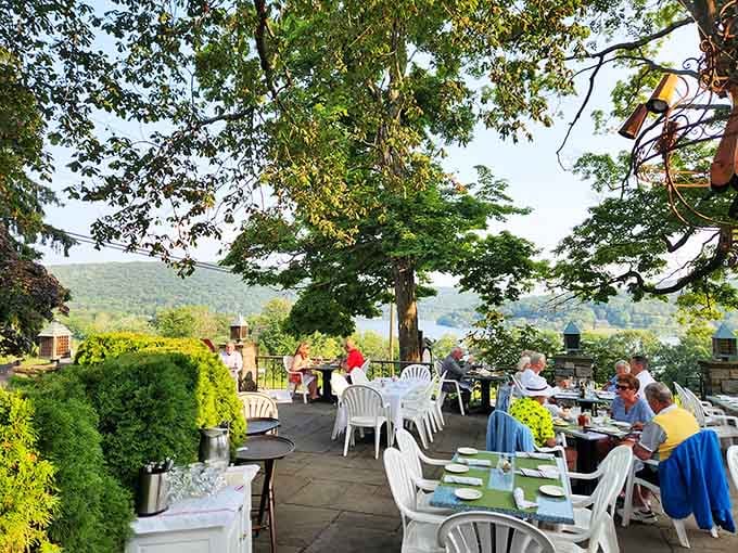 The outdoor terrace under mature trees is where European café culture meets New England charm in perfect harmony.