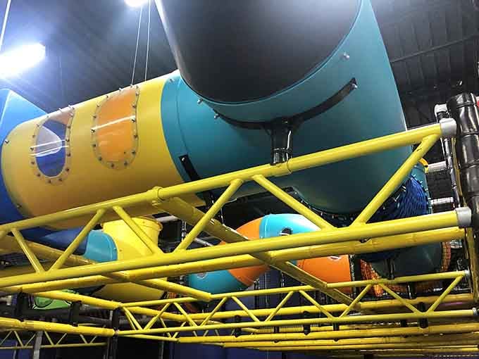 Massive tubes twist overhead like industrial art, engineering marvel designed specifically for crawling and giggling explorers.