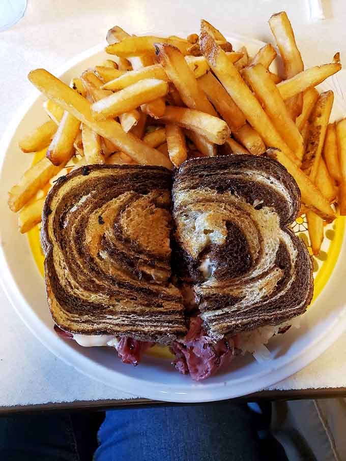 The Reuben on marbled rye sits atop a mountain of fries, daring you to finish it all.
