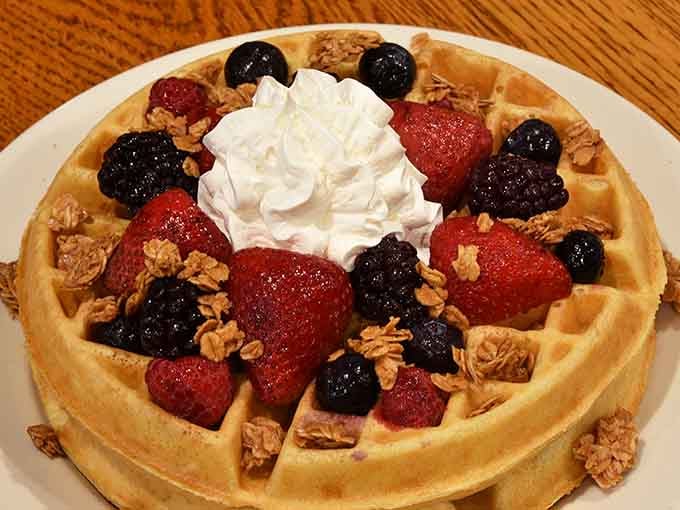 Belgian waffle topped with berries, granola, and whipped cream, basically breakfast's greatest hits album on one plate.