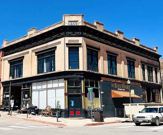 The Black Monarch Hotel anchors its corner with 1890s elegance, ornate details intact despite decades of weather and fortune's changes.