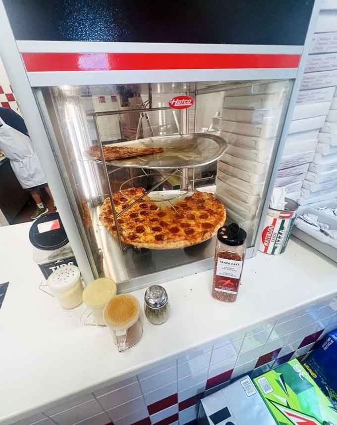 Fresh pies rotating under warm lights like edible treasures, ready to rescue hungry travelers from mediocre convenience store fare.