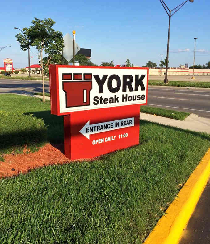 That bold red sign tells you everything you need to know: steak, value, and the entrance is around back.