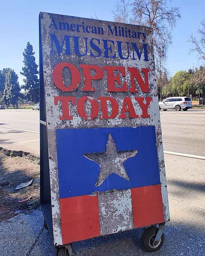 That weathered roadside sign beckons passersby to discover treasures hiding just beyond the everyday suburban landscape.