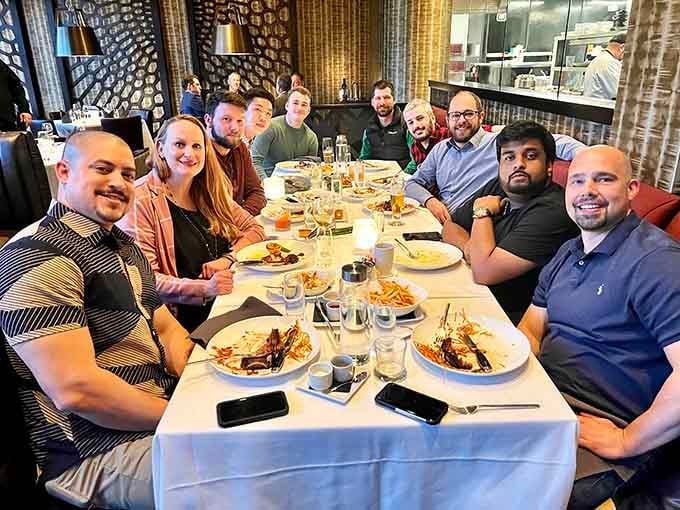 Happy diners gathered around a table full of incredible food, which is basically the definition of success.