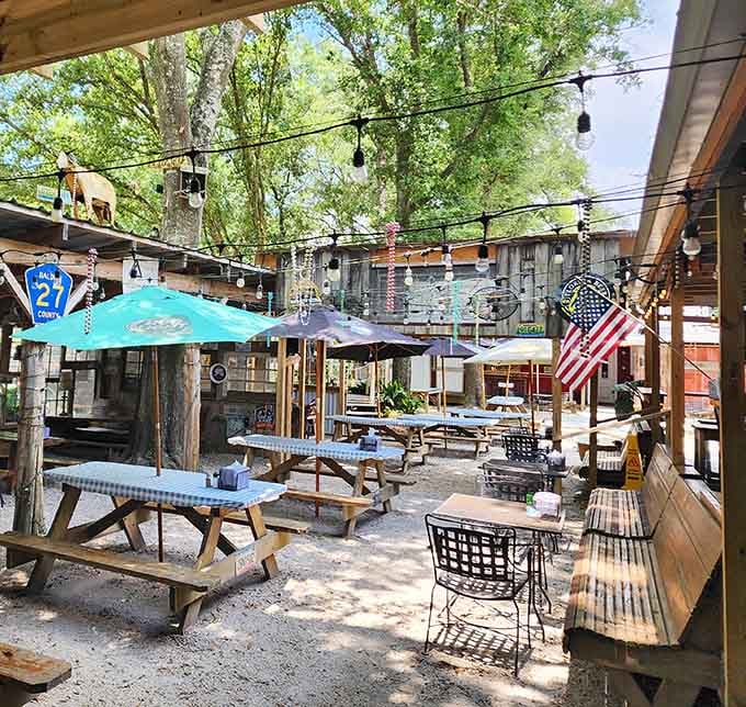 Outdoor seating under string lights and mature trees transforms a simple meal into a proper Southern dining experience.