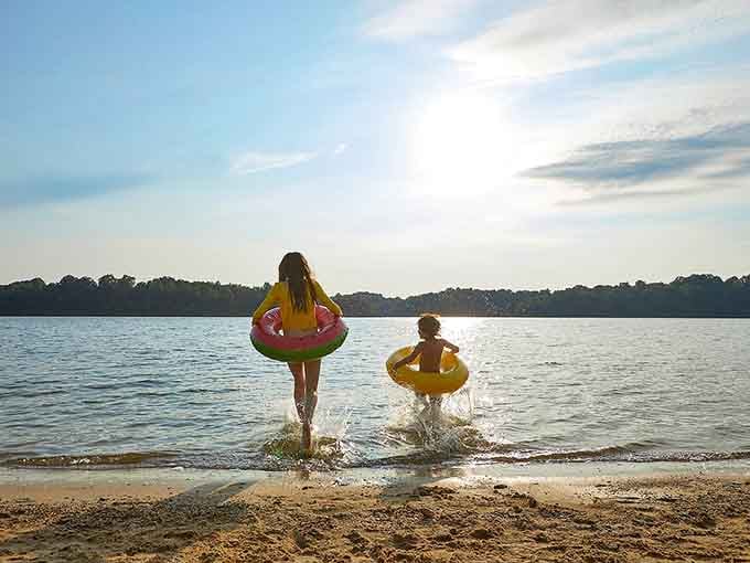 Two kids race toward the water with floaties, living their best landlocked beach life in Lucas.