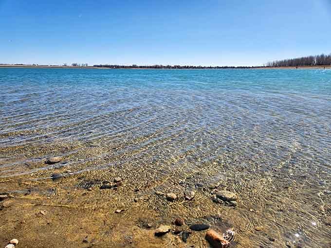 Crystal-clear shallow water reveals the sandy bottom, inviting you to wade in without mysterious depth anxiety.