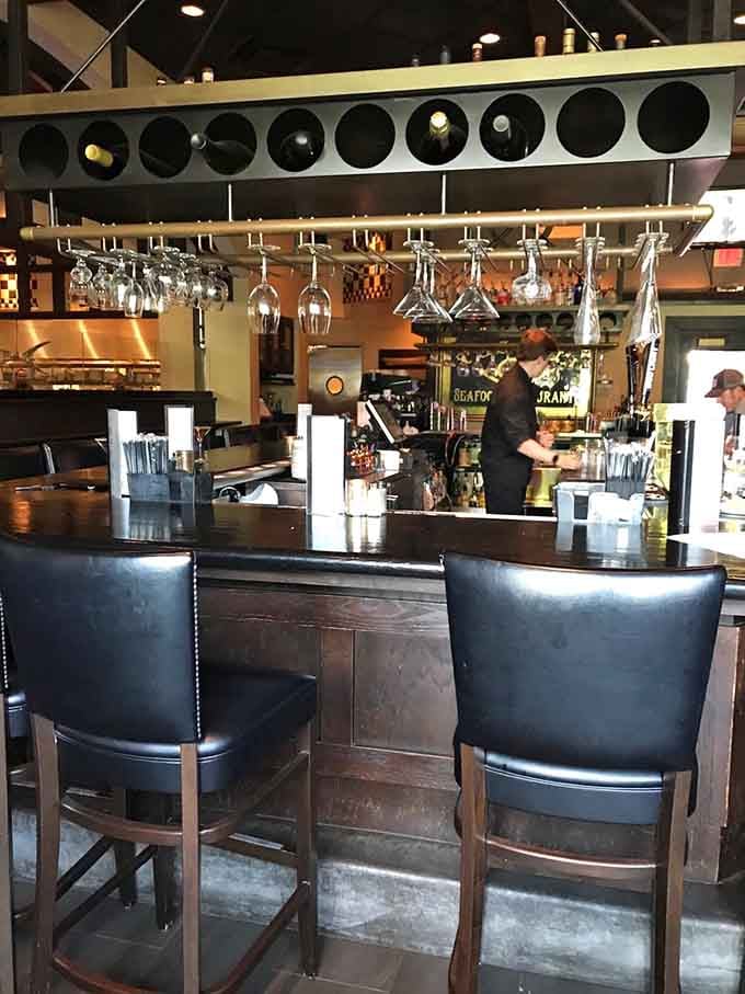 The well-stocked bar with hanging glassware signals serious attention to the beverage program that complements every meal perfectly.