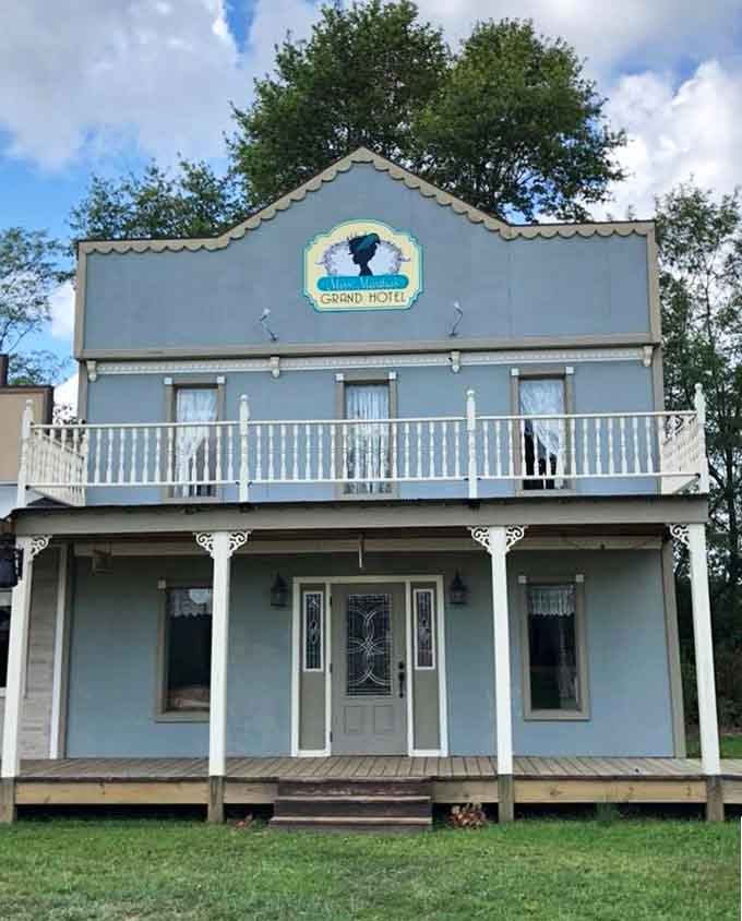 The Grand Hotel's baby blue facade suggests this establishment catered to travelers seeking comfort on the dusty trail.