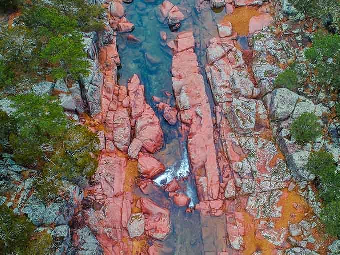 From above, the river cuts through pink rock like a sapphire ribbon, revealing patterns that took millennia to perfect.