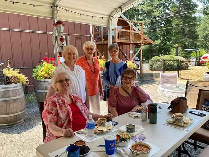 Five smiling friends enjoying their meal together capture exactly what makes this place special beyond the food itself.