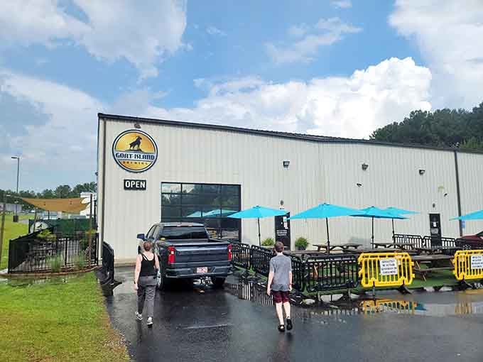 Bright turquoise umbrellas pop against industrial metal, proving breweries can be both laid-back and Instagram-worthy simultaneously.