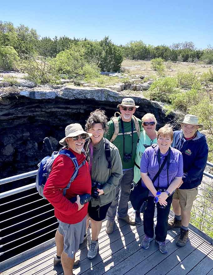 Tour groups bonding over shared wonder, proving that staring into a giant hole together creates surprisingly strong friendships quickly.