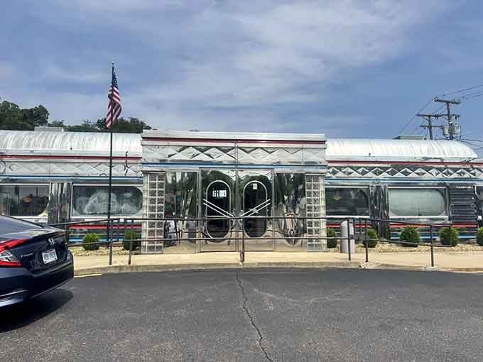 The American flag waves proudly above this chrome palace, welcoming travelers to experience authentic diner culture today.