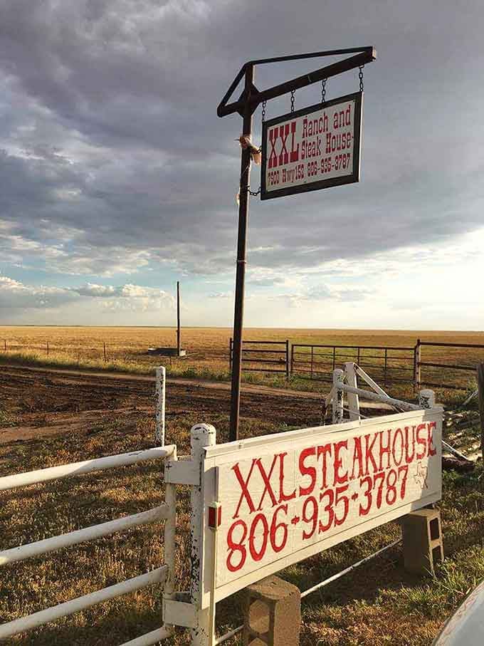 That sign against endless sky and prairie grass marks the spot where civilization ends and legendary steaks begin their magic.