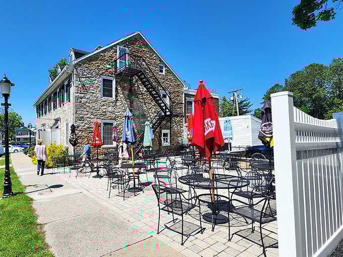 The outdoor patio with colorful umbrellas offers al fresco dining against the backdrop of this magnificent historic stone building.