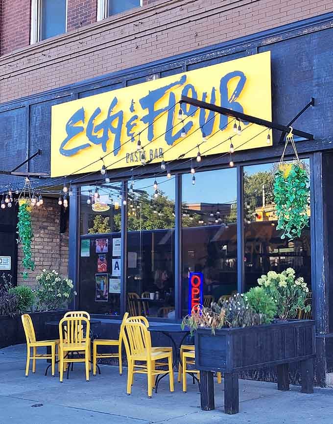 Sidewalk seating framed by planters and that sunny yellow sign turns a simple meal into a Milwaukee moment.