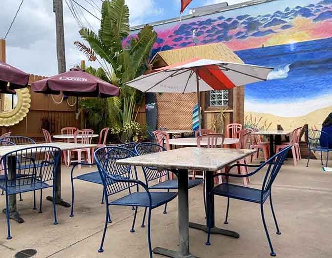 Outdoor patio seating with umbrellas and a vibrant mural, perfect for enjoying Florida weather while devouring fresh seafood.