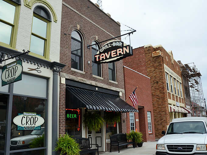 The neon beer sign glows green like a beacon guiding weary travelers to cold drinks and good company.