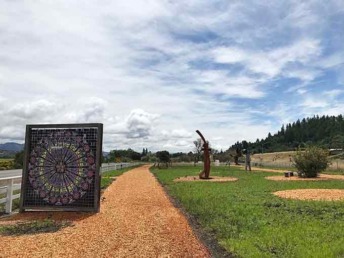 The trail stretches ahead beneath dramatic clouds, inviting wanderers to discover what artistic surprises wait around each bend.