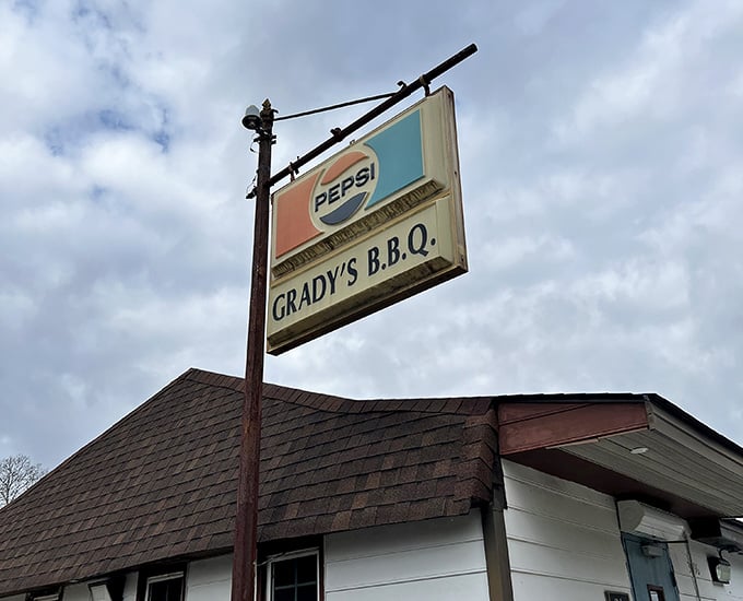 The vintage Pepsi sign hanging proudly above Grady's BBQ is like a beacon guiding hungry travelers to smoked pork paradise.